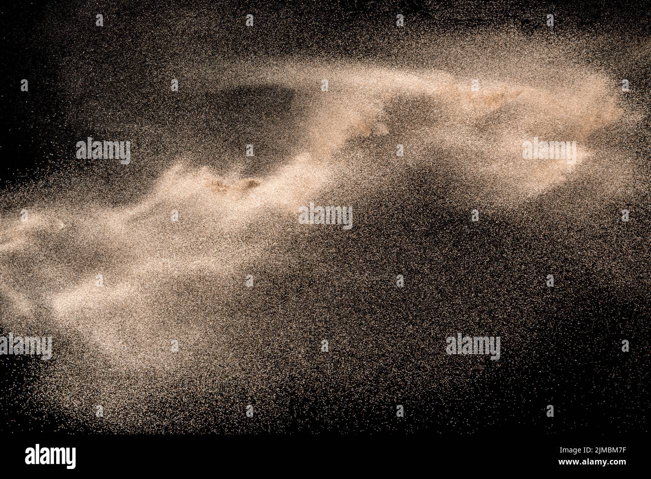 Dry river sand explosion. Golden colored sand splash against black ...