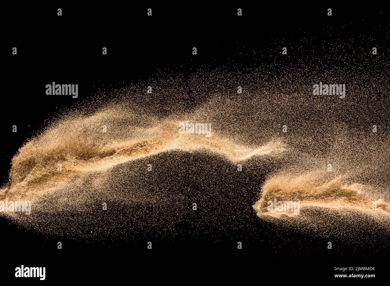 Dry river sand explosion. Golden colored sand splash against black ...
