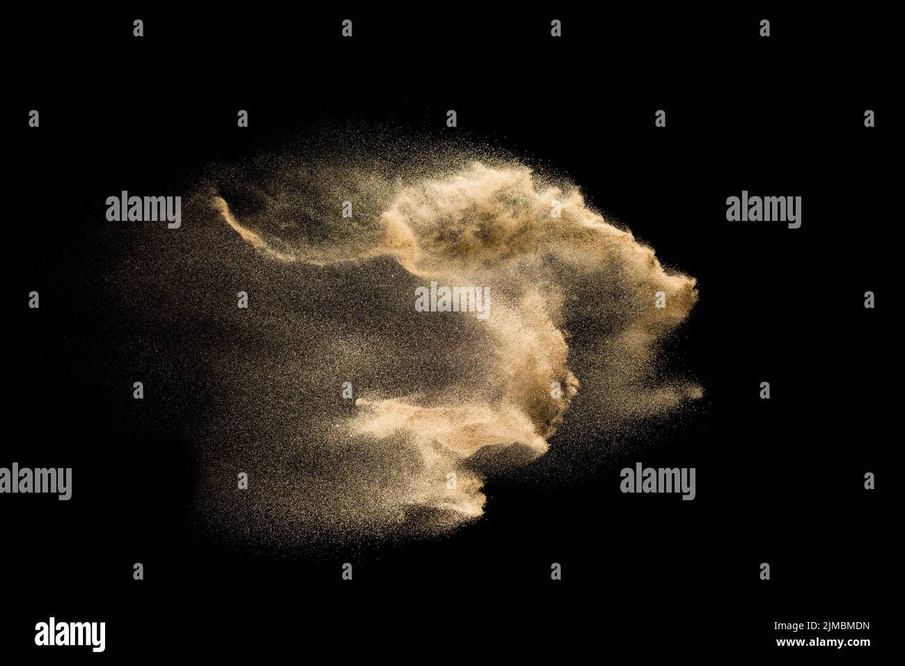 Abstract sand cloud. Golden colored sand splash against dark background ...