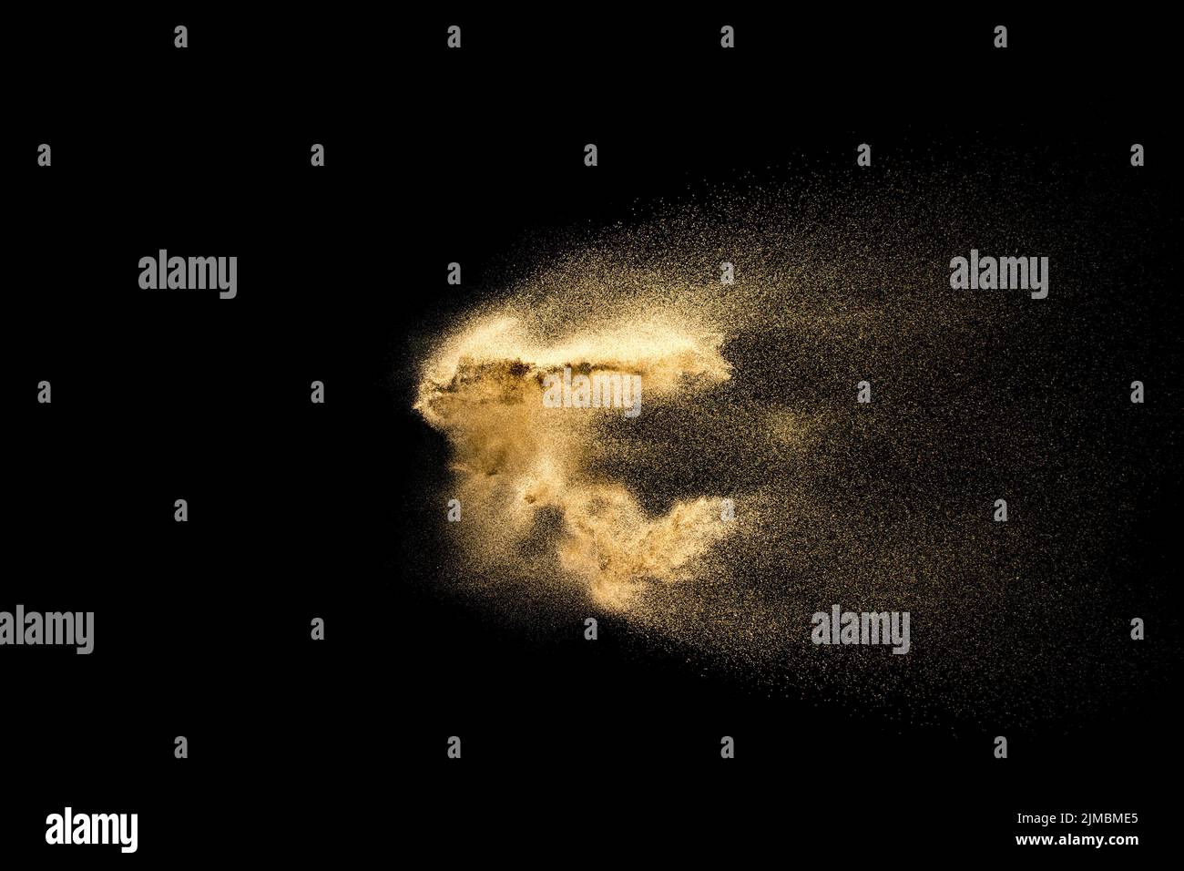 Abstract sand cloud. Golden colored sand splash against dark background ...