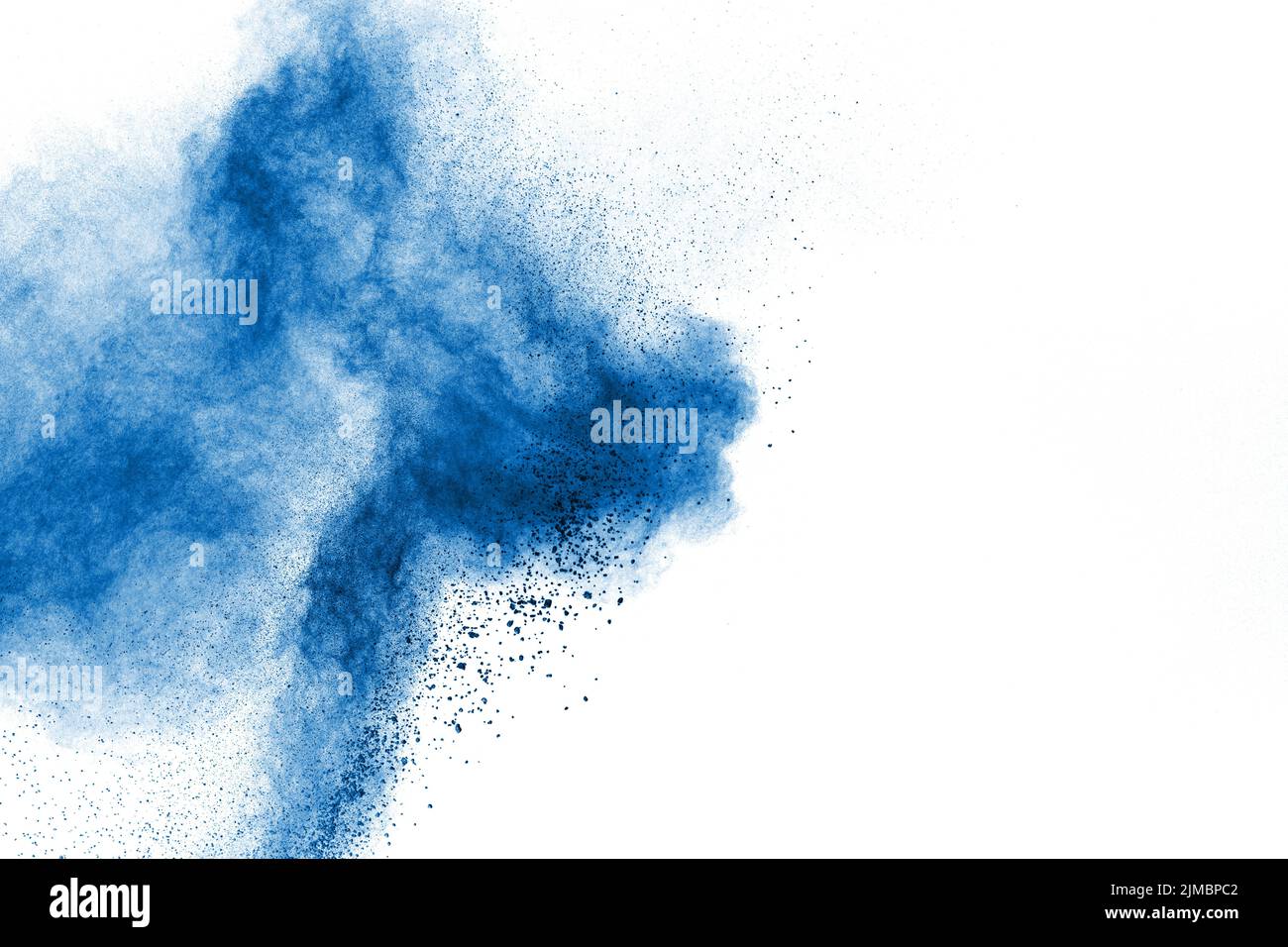 Abstract blue dust explosion on white background. Freeze motion of blue ...