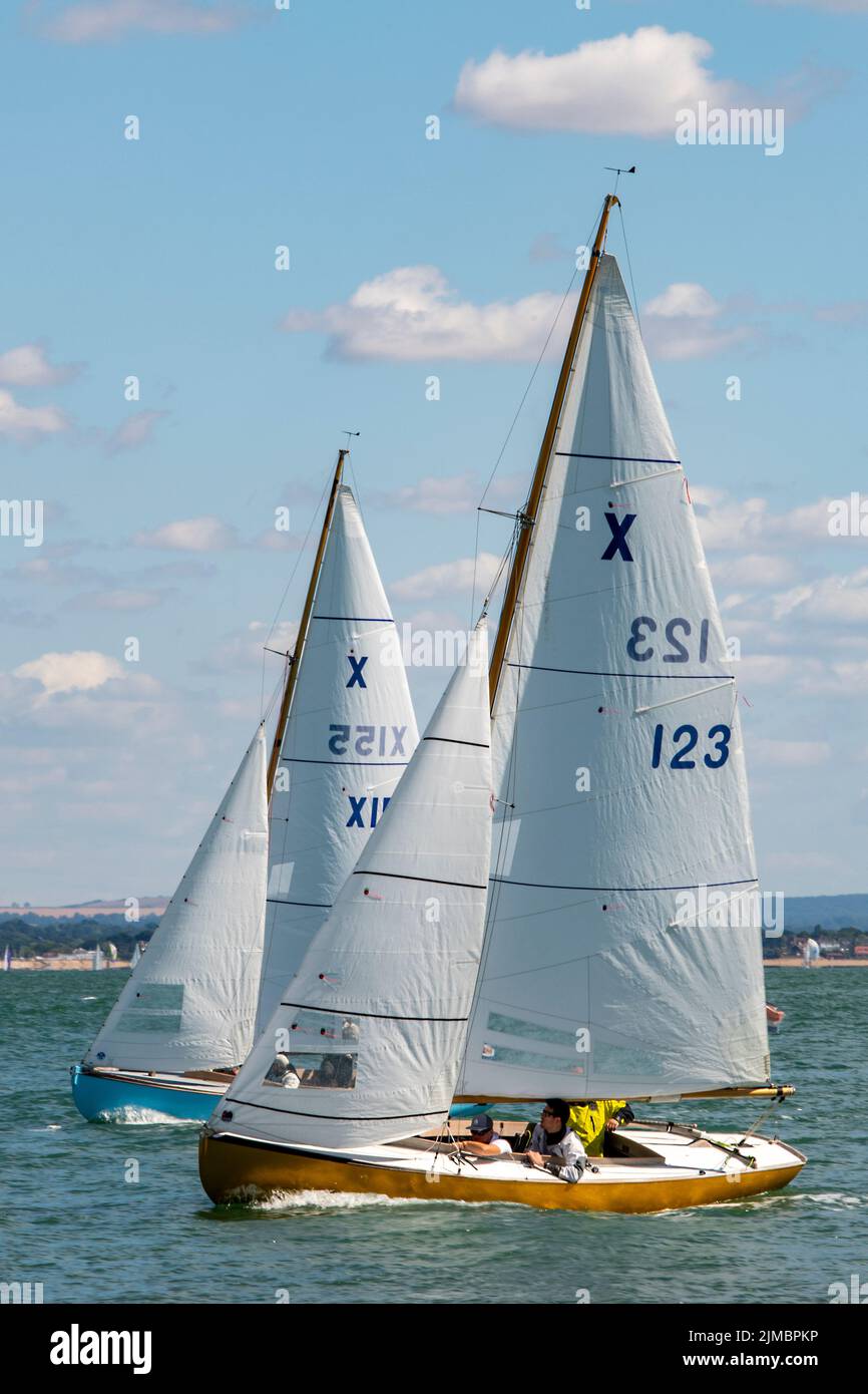 yachts and dinghies racing off of the coast of the isle of wight during ...