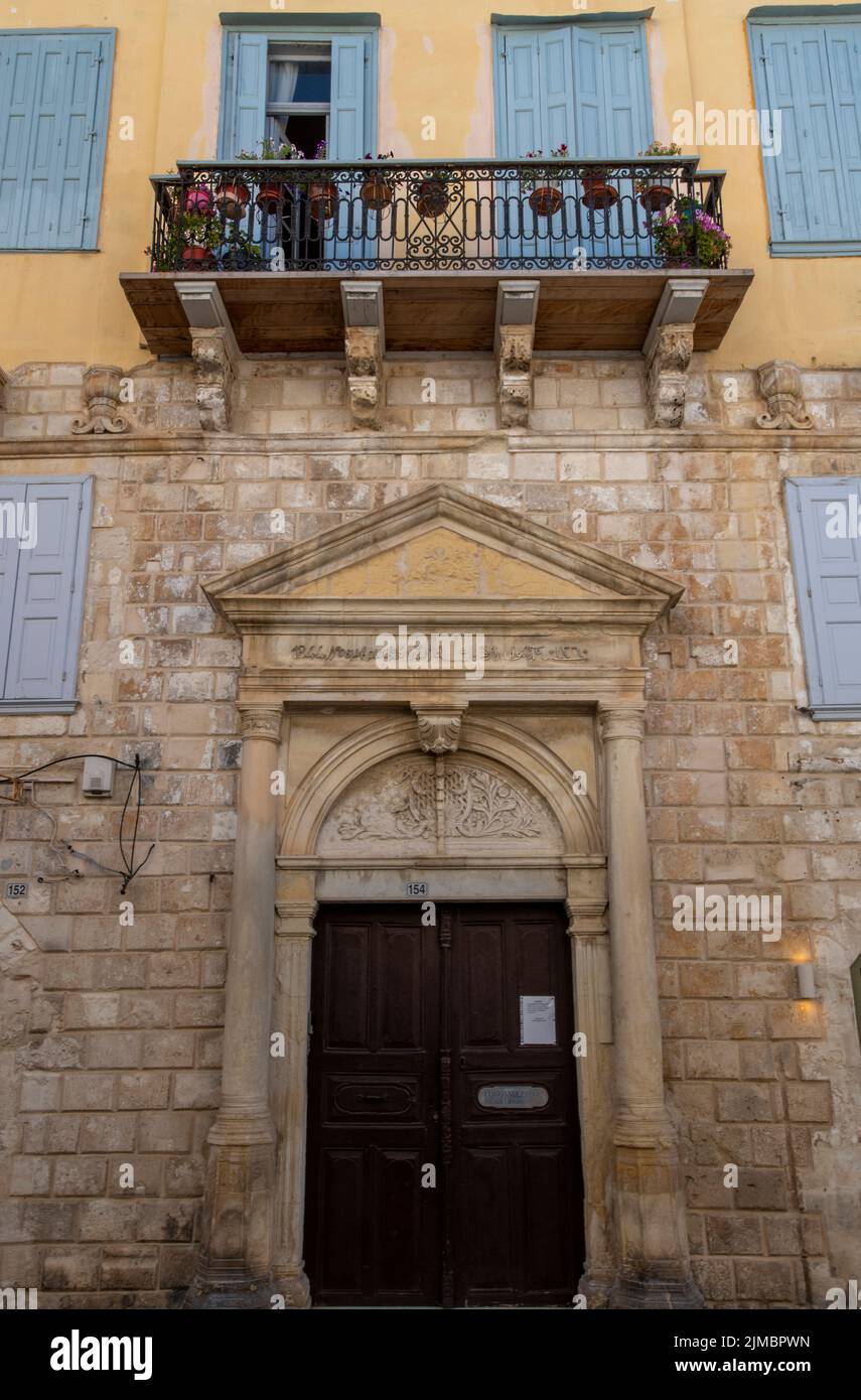 historic doorway with stone pediment and a wrought iron ornat balcony ...