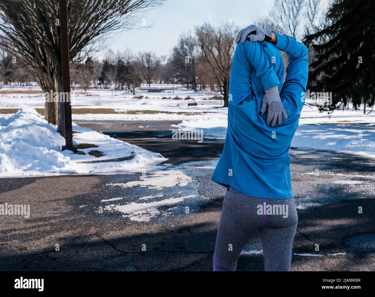 Woman warming up, stretching her arms before her early morning exercise ...