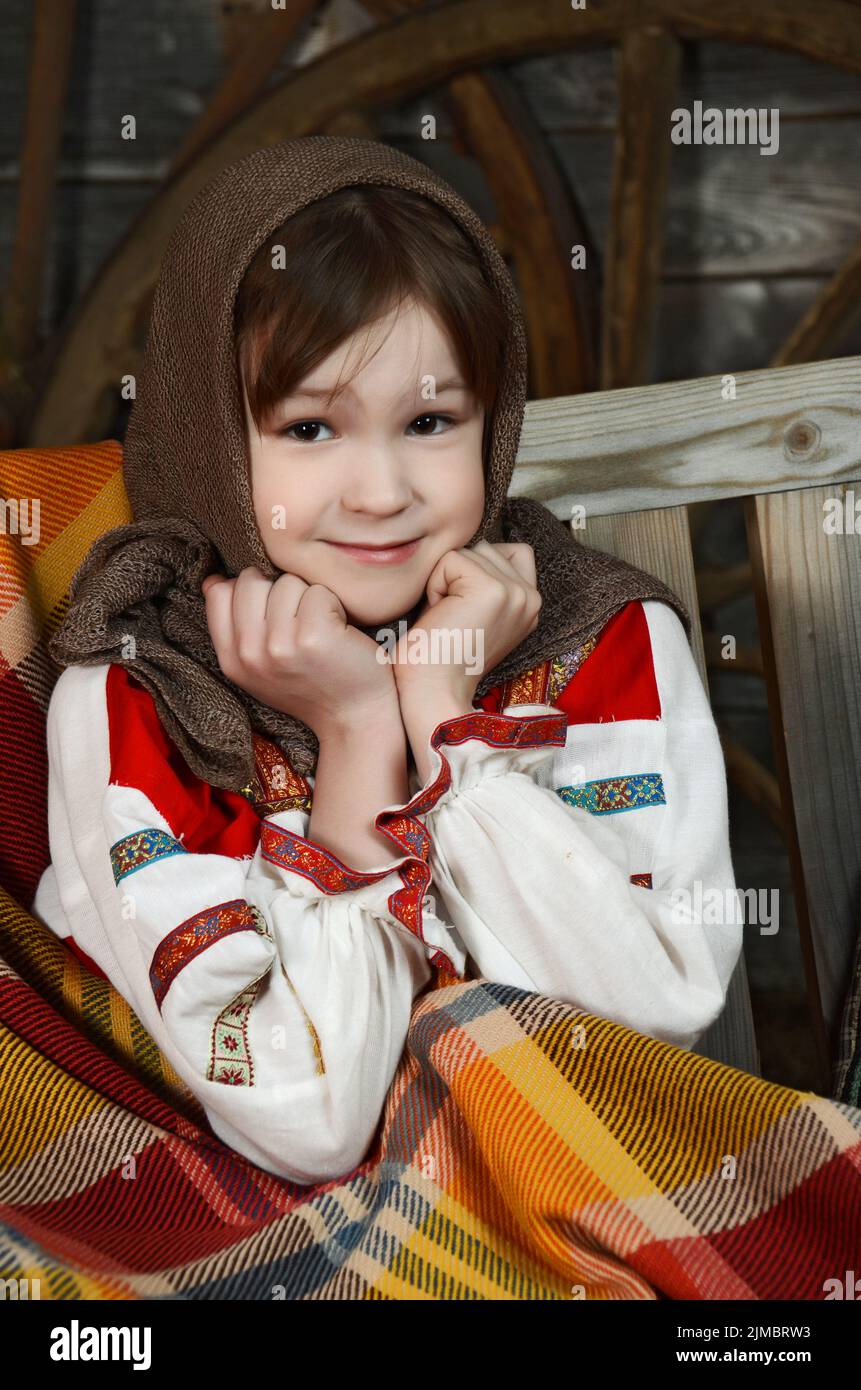 Beautiful girl in russian costume sitting in a traditional interior ...