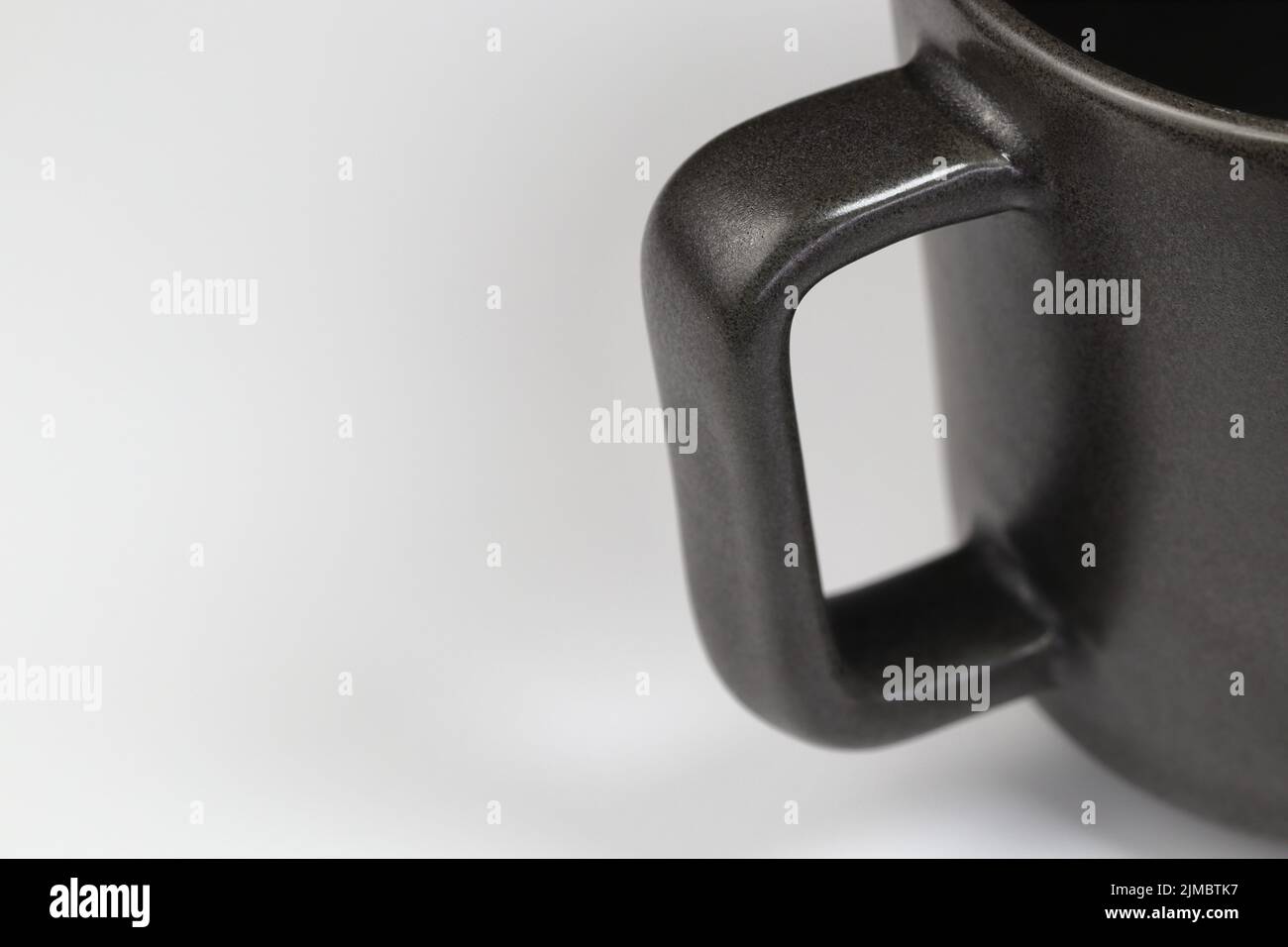 Close up black ceramic cup handle with white background Stock Photo - Alamy