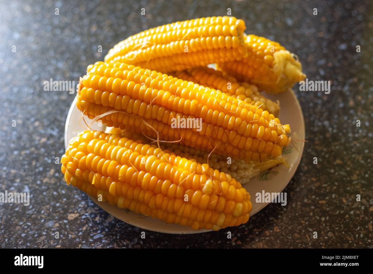ripe yellow corn on the cob on a plate on a black table Stock Photo - Alamy