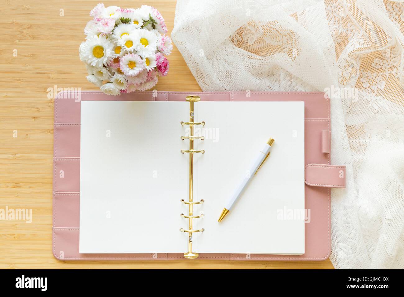 Flat lay, top view of a pastel pink planner, flower bouquet and ...