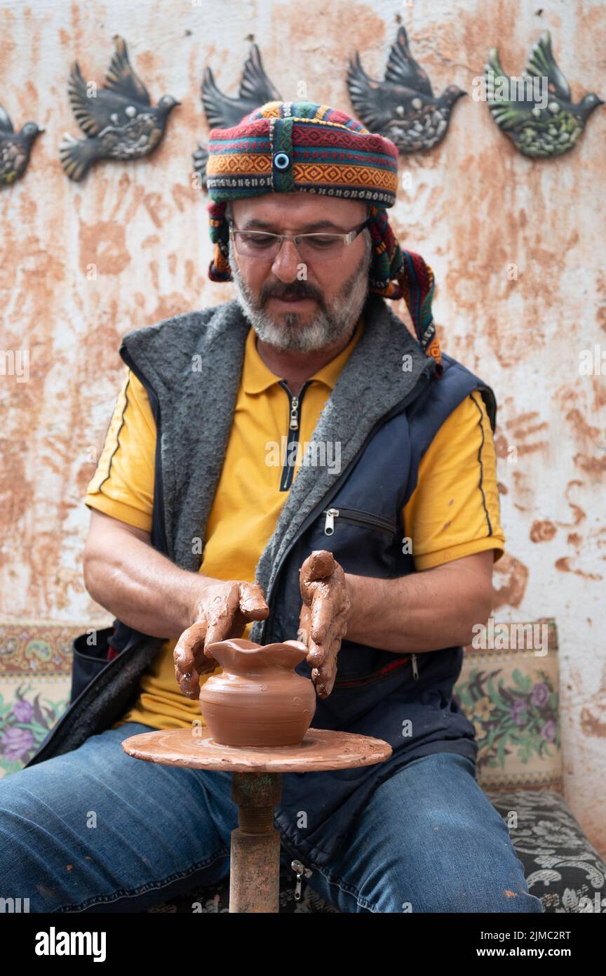 Avanos, Turkey. 27th June, 2022. A potter with a chapka sits in front ...