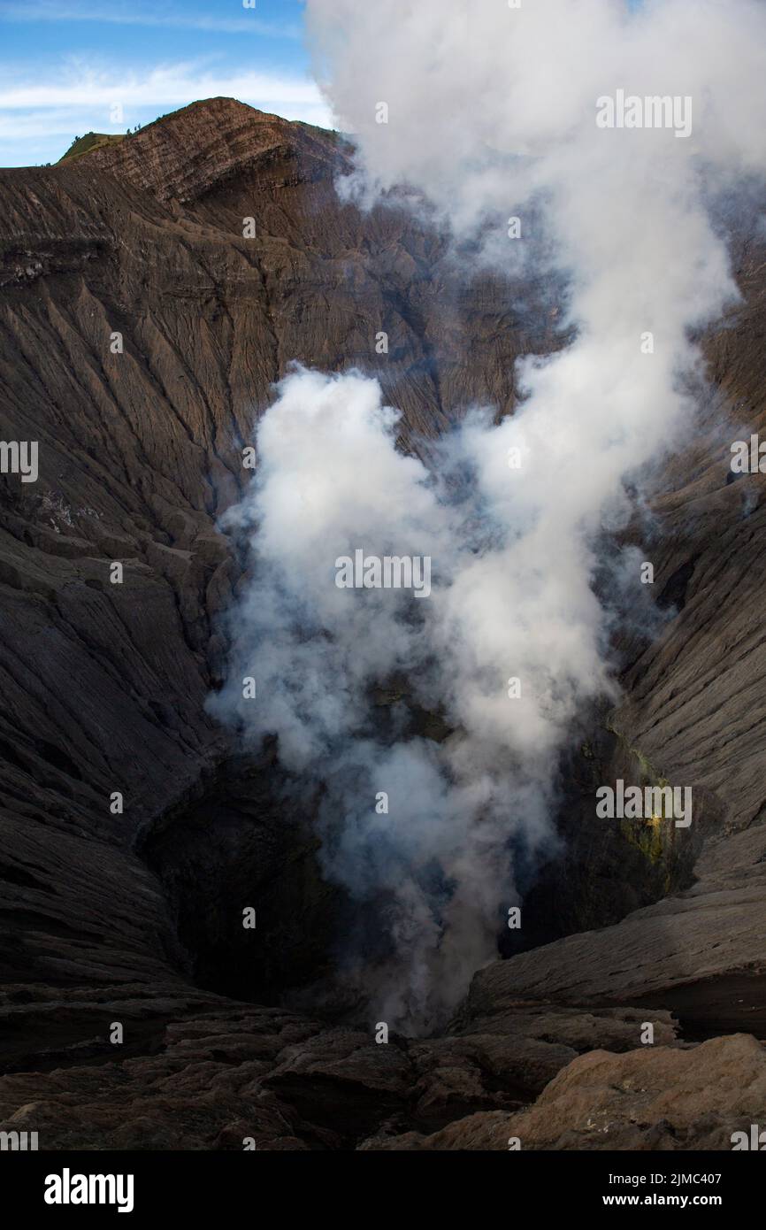 View into volcanic crater of active volcano Bromo with steam and smoke ...