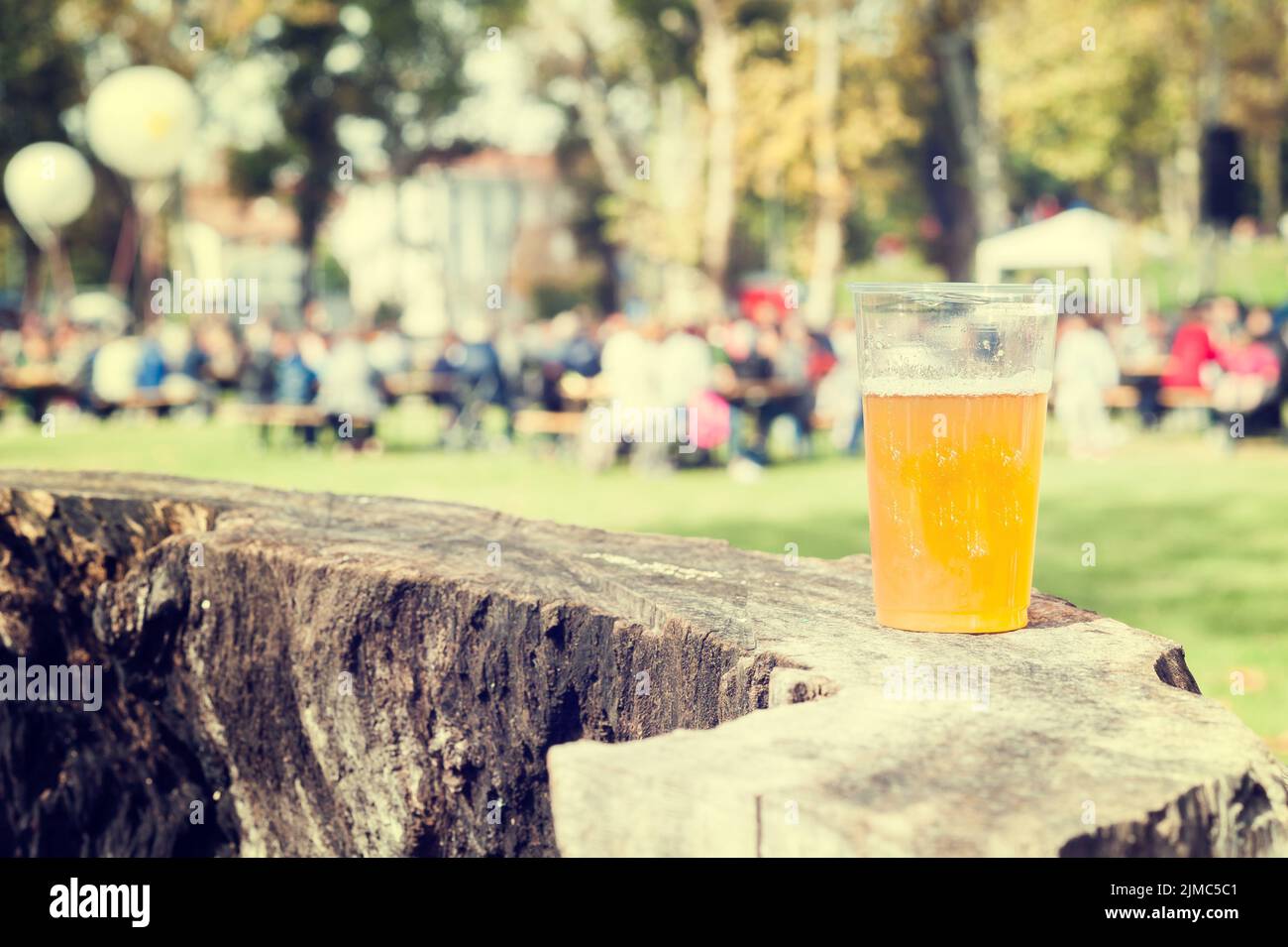 Plastic cup of beer on a tree trunk. Vintage style photo Stock Photo ...