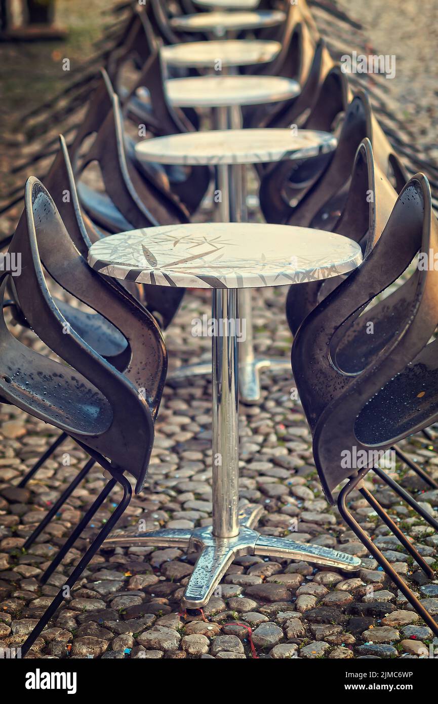 Tables and chairs lined up outdoors in a public place Stock Photo - Alamy