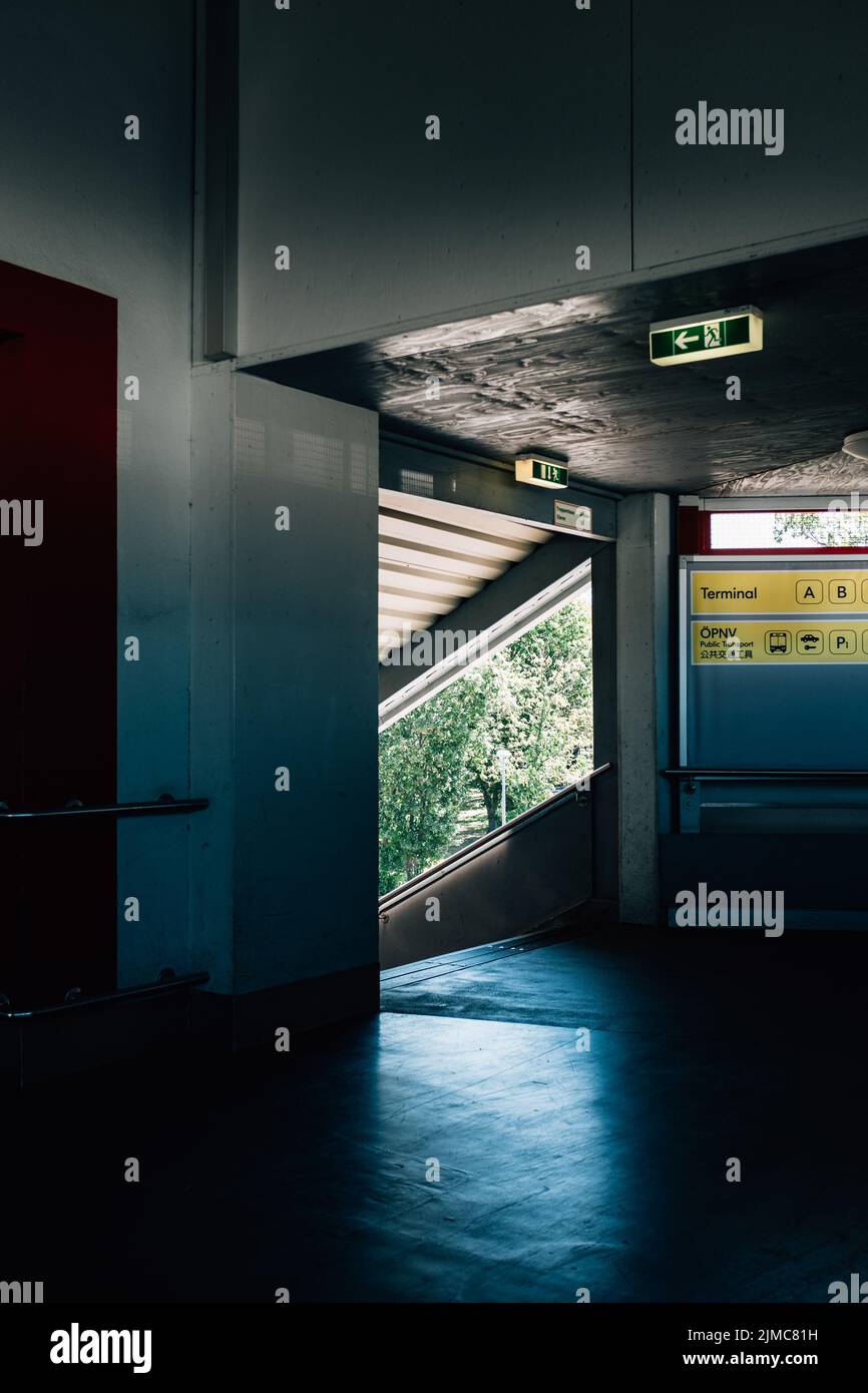 A vertical shot of an empty hallway leading to a downwards staircase ...