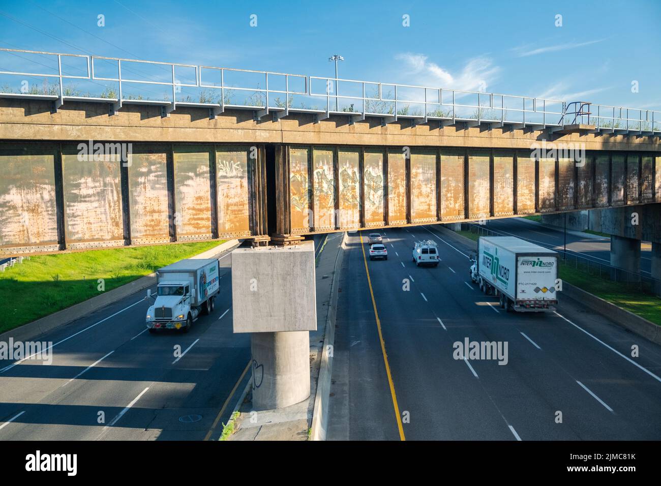 A railroad line crosses over a busy highway Stock Photo - Alamy