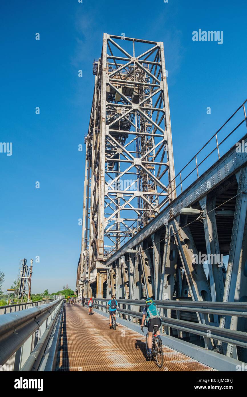 Cyclists next to a canal boat lift on a morning commute riding Stock ...