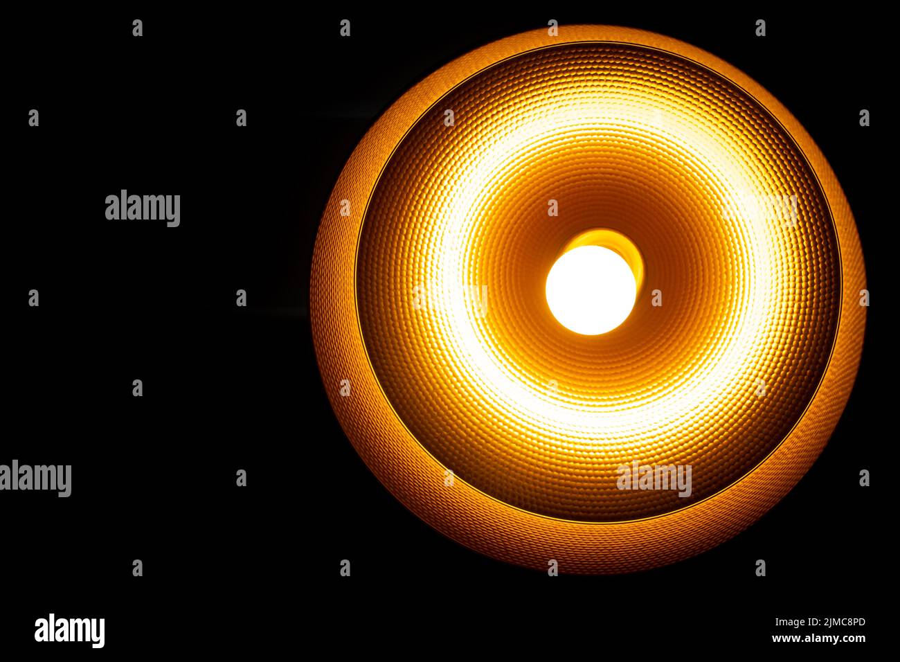 A Modern lamp hanging down from ceiling in the dark background ...