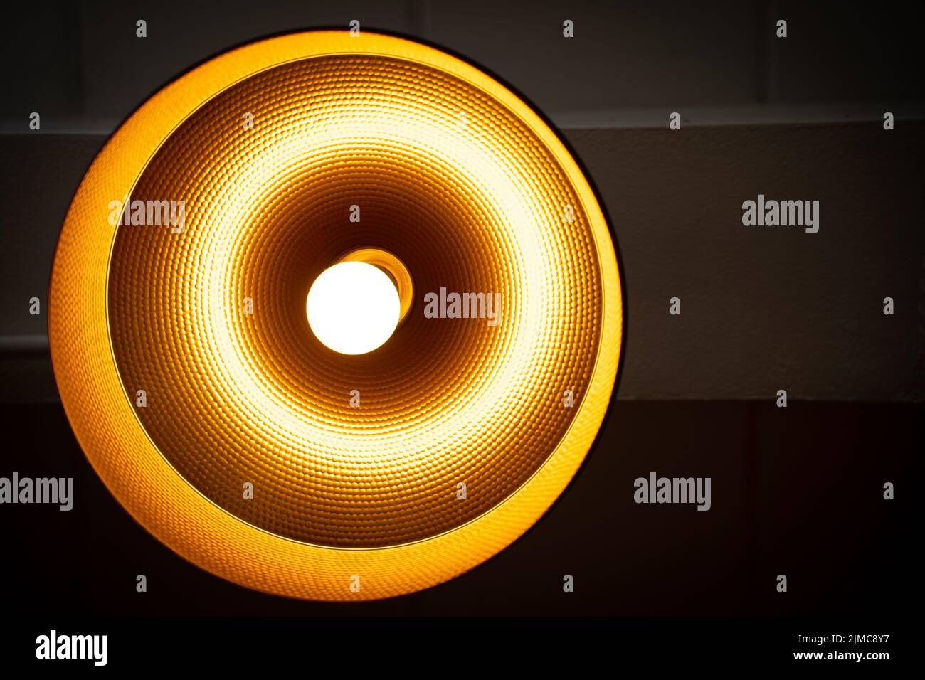 Modern lamp hanging down from ceiling in the dark background ...