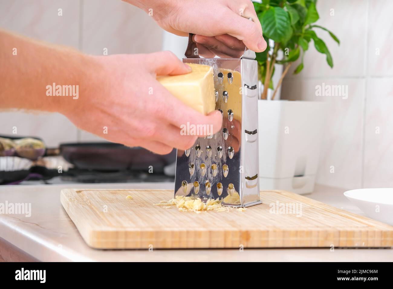 Man rubs hard grated cheese hi-res stock photography and images - Alamy