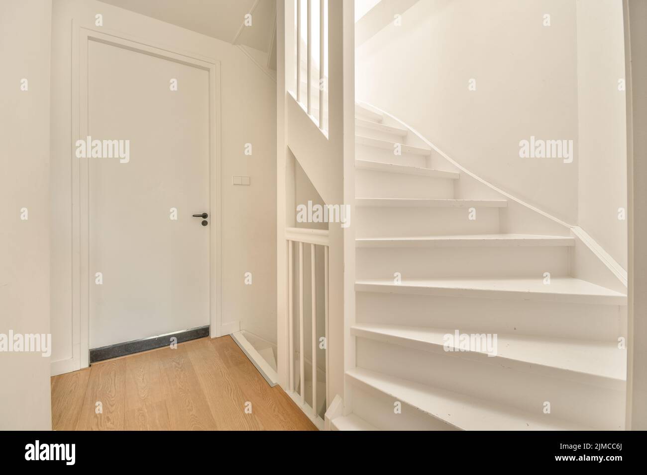 From above of narrow spiral stairway with white stairs and railing on ...