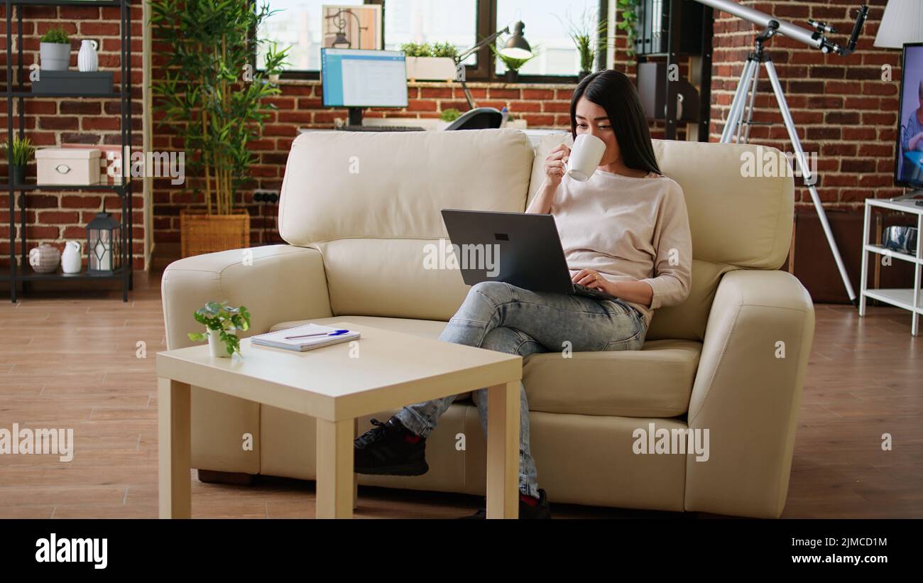 Focused young adult asian student attending online class while typing ...