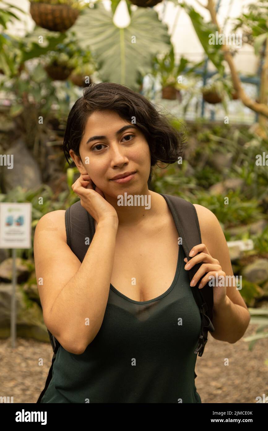 tourist on vacation inside a garden with nature, young latin woman with ...