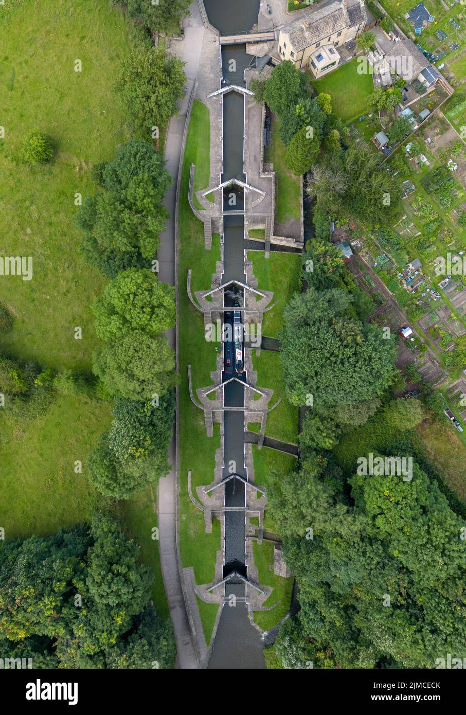 an aerial drone shot of 2 canal barges climbing the Five-Rise Locks a ...