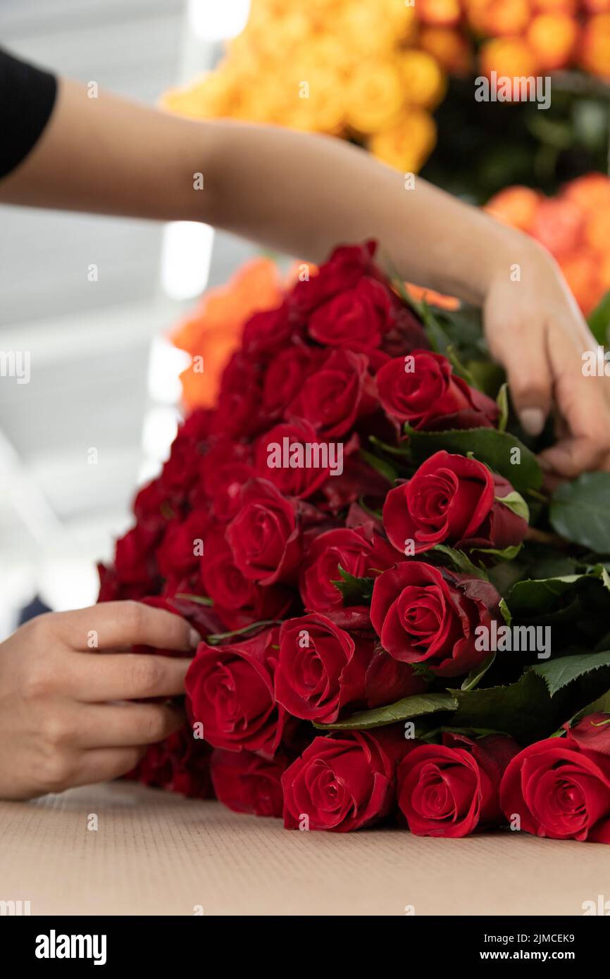 making a floral arrangement with natural red roses, details of petals ...