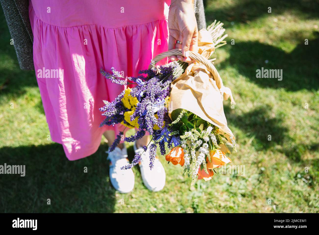 summer bouquet of yellow yarrow and lavender bouquet in woman's hands ...