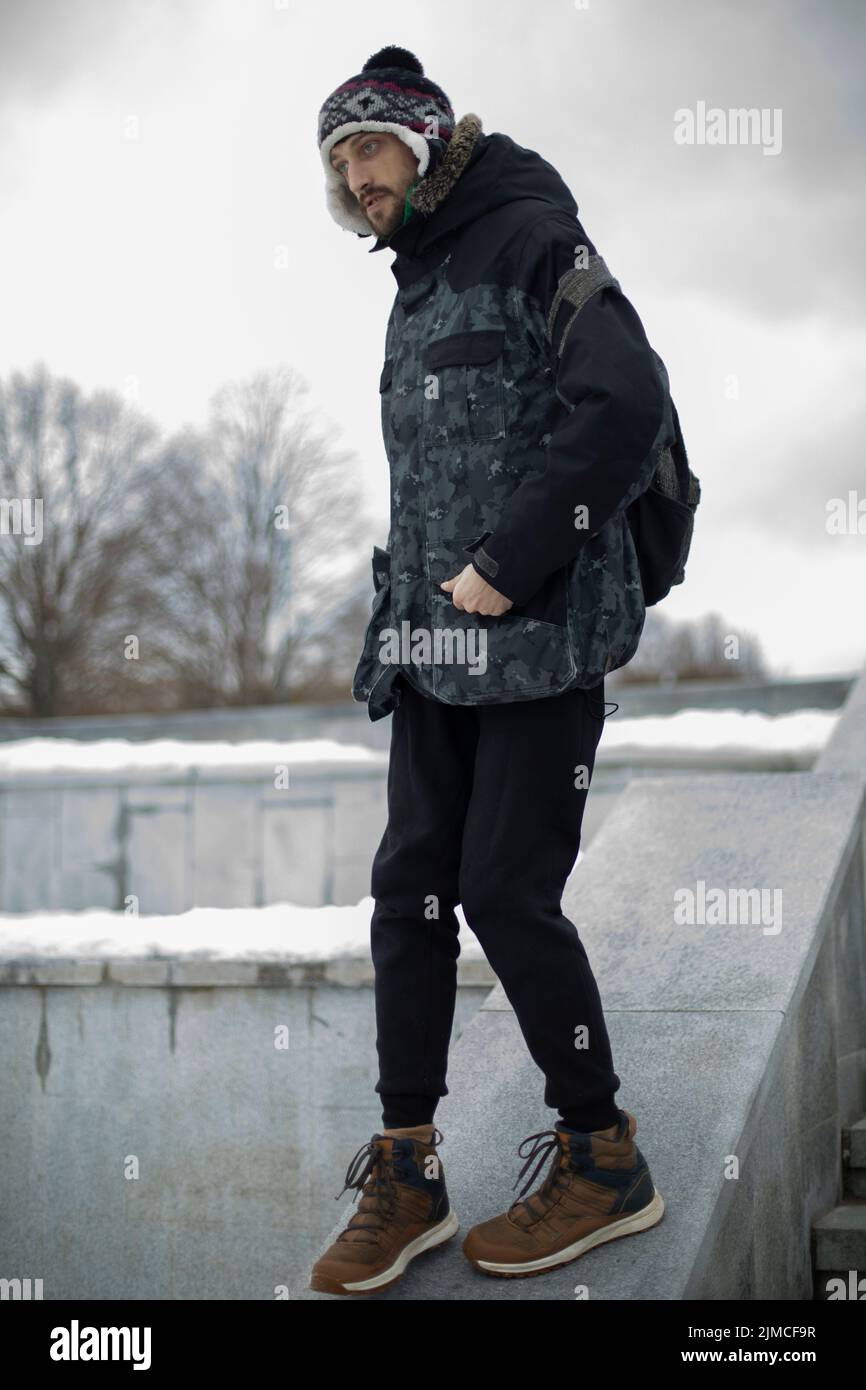 Man in town in winter. Dark blue color in clothes. Modern young man of ...