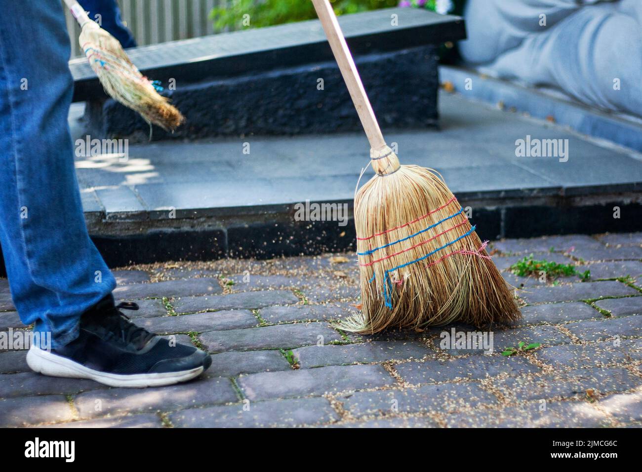 Cleaning the area with a broom. A man is sweeping the street. Cleaning ...