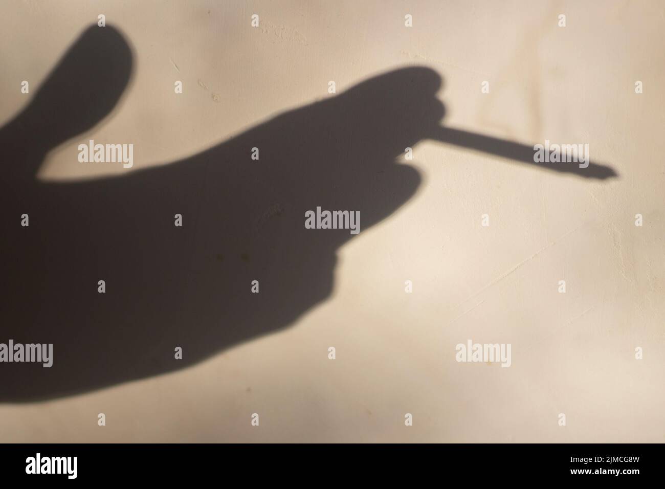 Shadow of a cigarette in hand. Smoking is harmful to your health ...