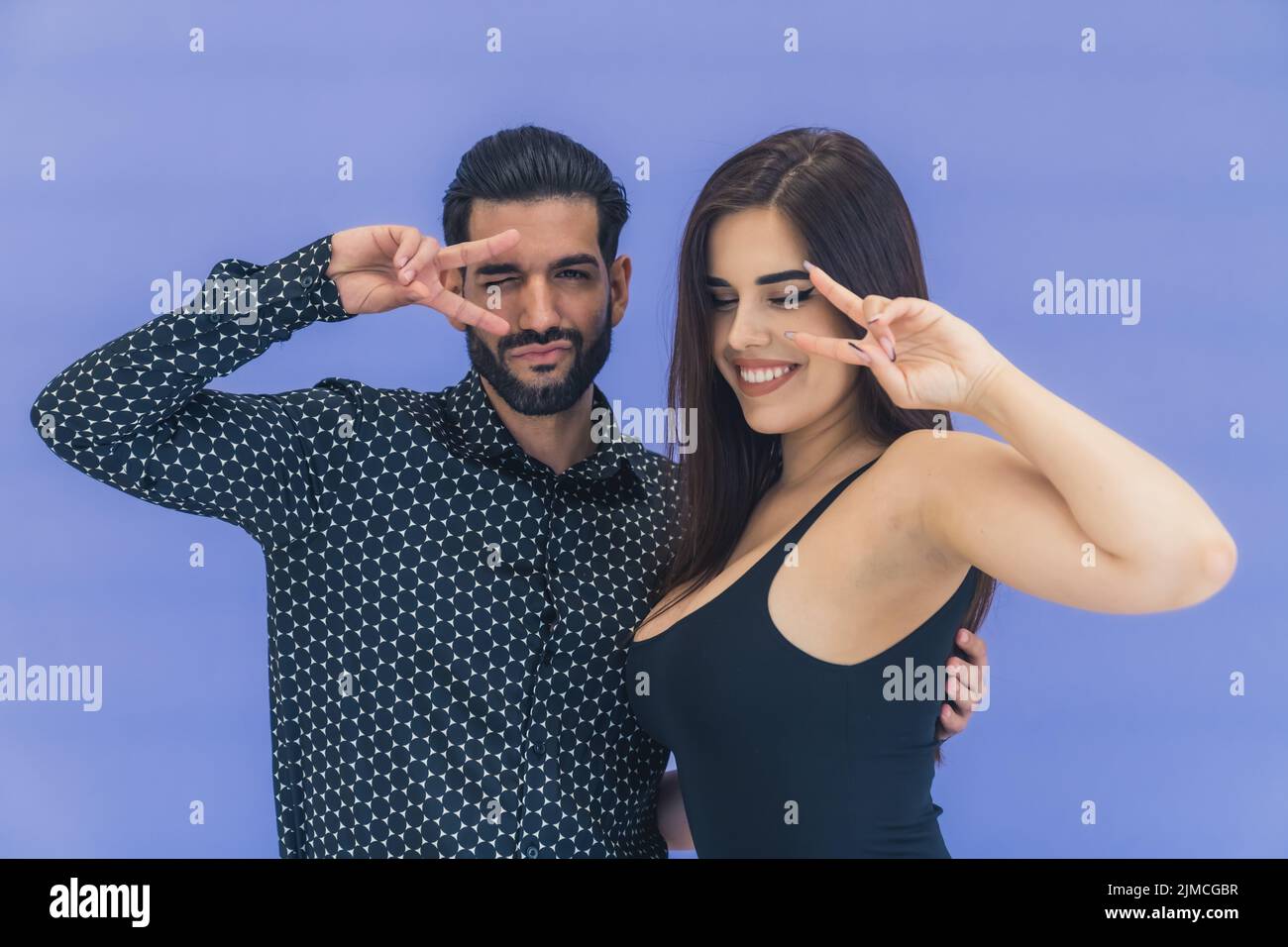 Happy couple hugging posing for picture together with peace signs in ...