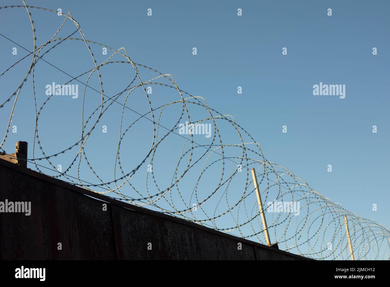 Barbed wire on fence. Private territory. High fence. Safety system ...