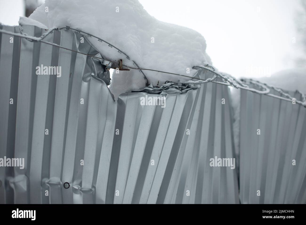 Broken fence. Snow bent metal. Collapse of fence. Consequences of ...