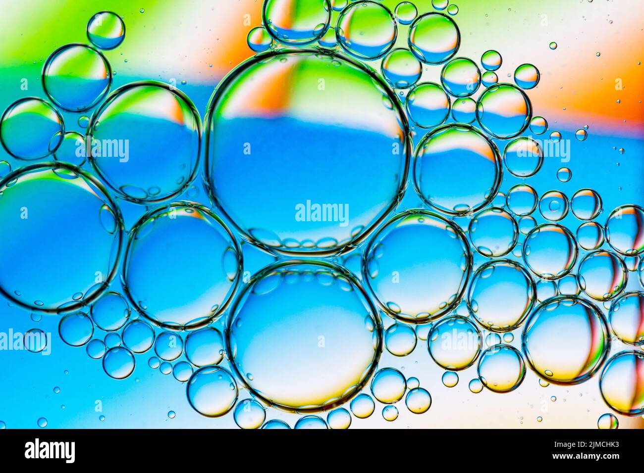 Abstract Background of Oil Bubbles on Water Surface cyan orange green ...