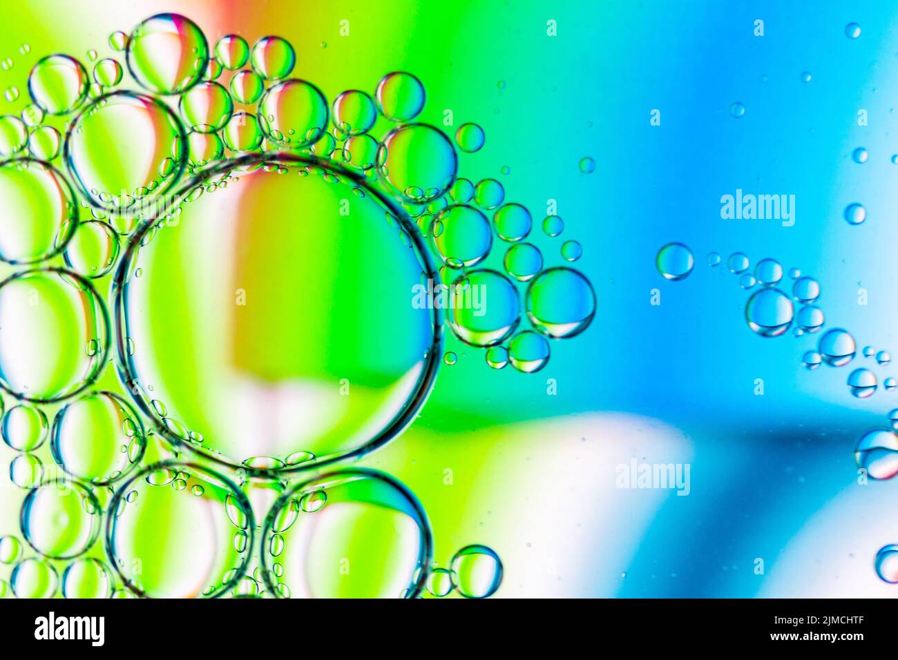 Abstract Background of Oil Bubbles on Water Surface cyan orange green ...