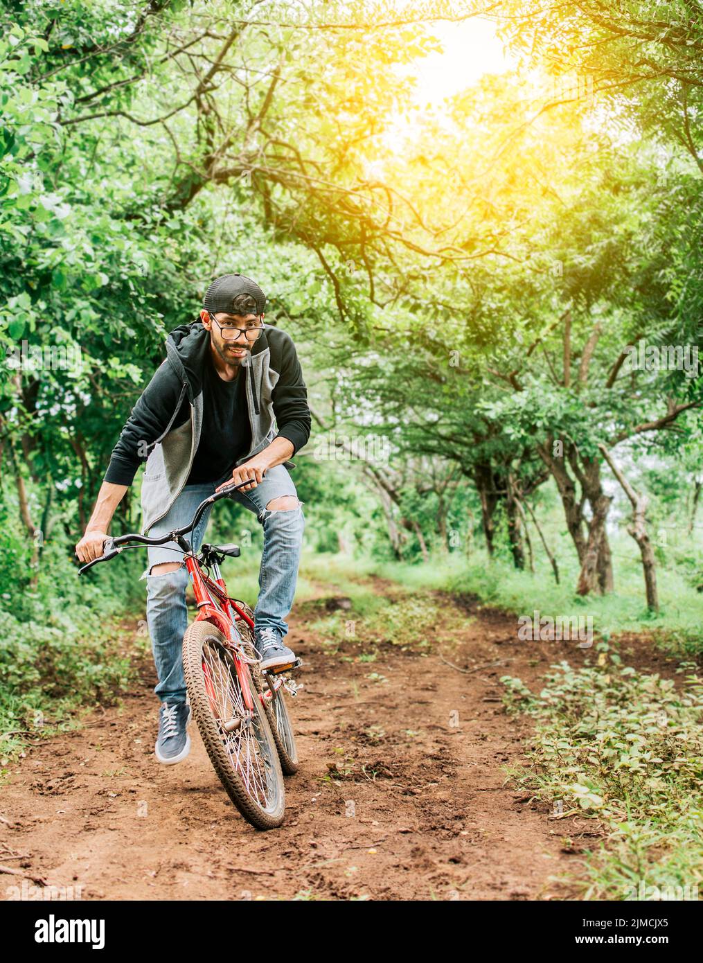 Person riding a bike in the countryside, Portrait of a guy in cap ...