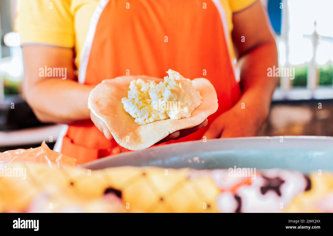Hands of a vendor showing traditional raw pupusa. Elaboration of ...