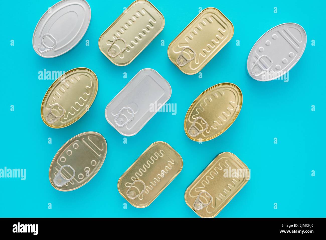 Top view row of unopened cans on a blue background Stock Photo - Alamy