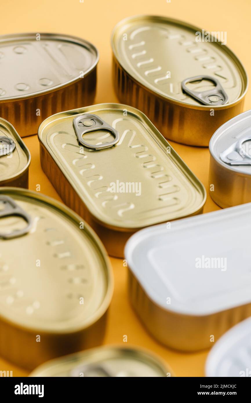Top view row of unopened cans on a yellow background Stock Photo - Alamy