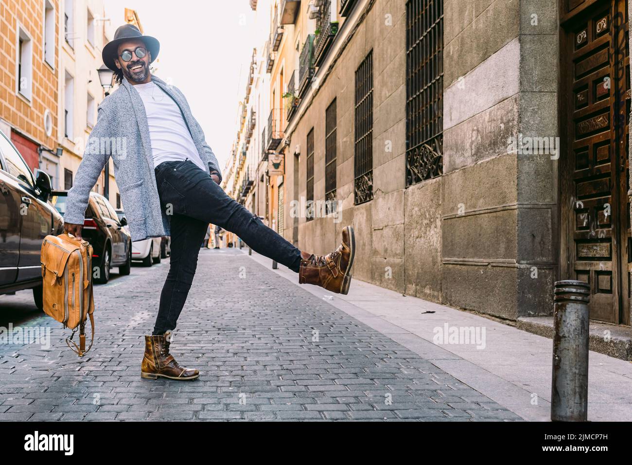 Full body happy Hispanic male in trendy outfit with leather bag smiling ...