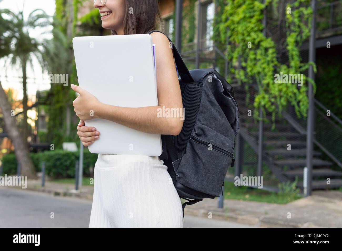 Side view of happy cropped unrecognizable female student with modern ...