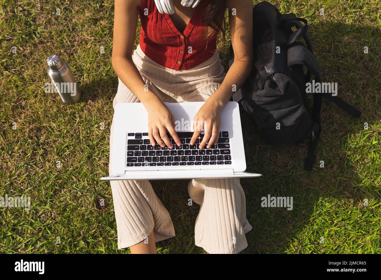 Top view of anonymous female student typing on netbook while doing ...