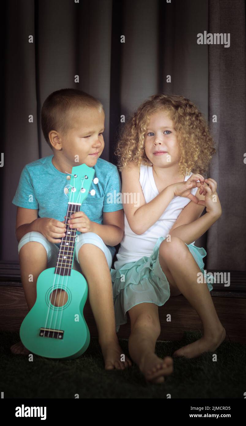 Portrait of a cute kids with ukulele Stock Photo - Alamy