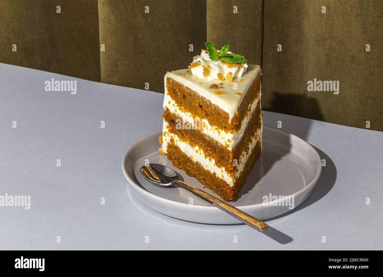 Slice of tasty sweet carrot sponge cake with cream decorated with mint ...