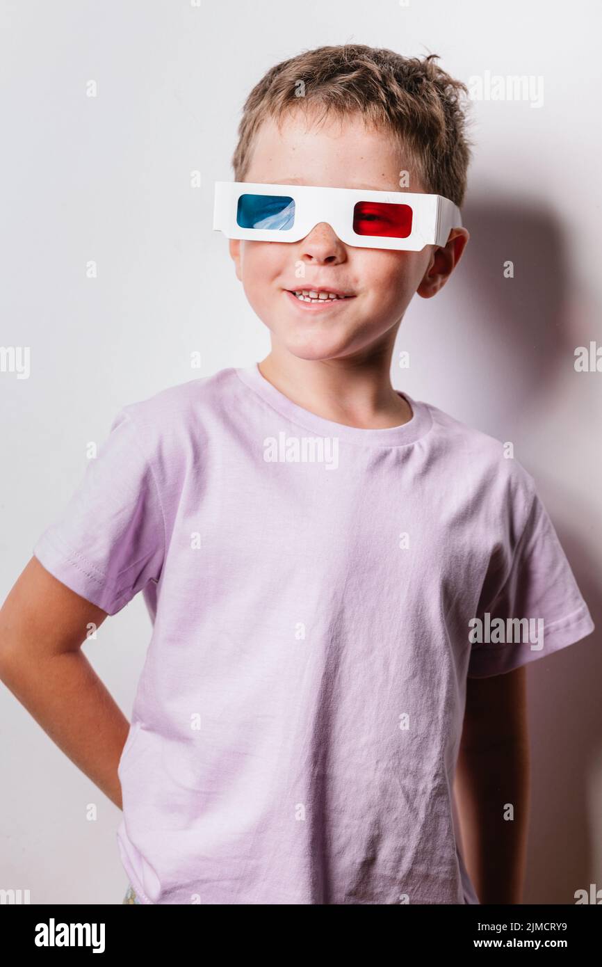 Cute happy boy in casual wearing 3D glasses with colorful lenses while ...