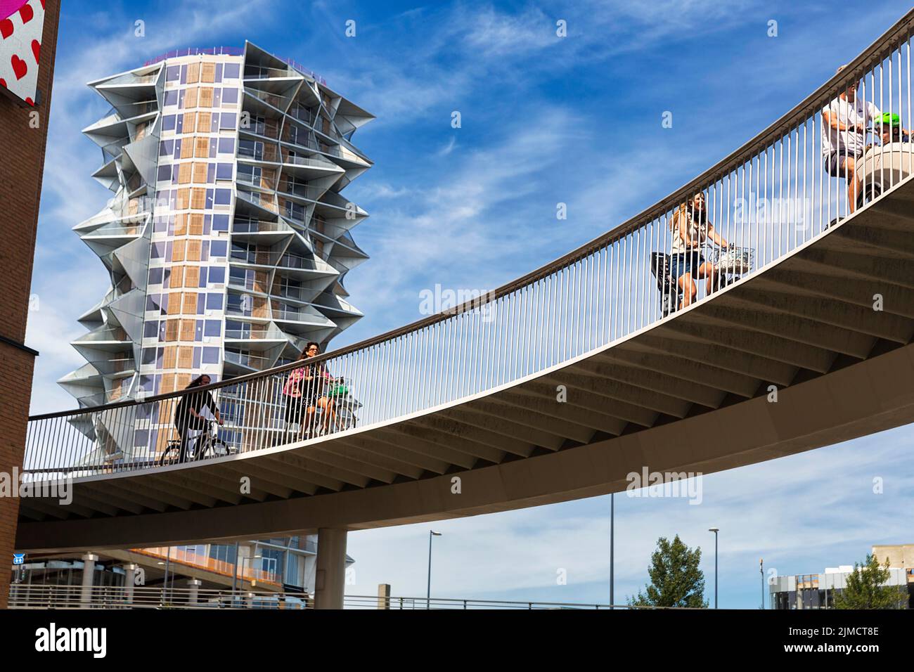 Cyclists on bridge at Kaktus Tower skyscraper, Cykelslangen bicycle ...