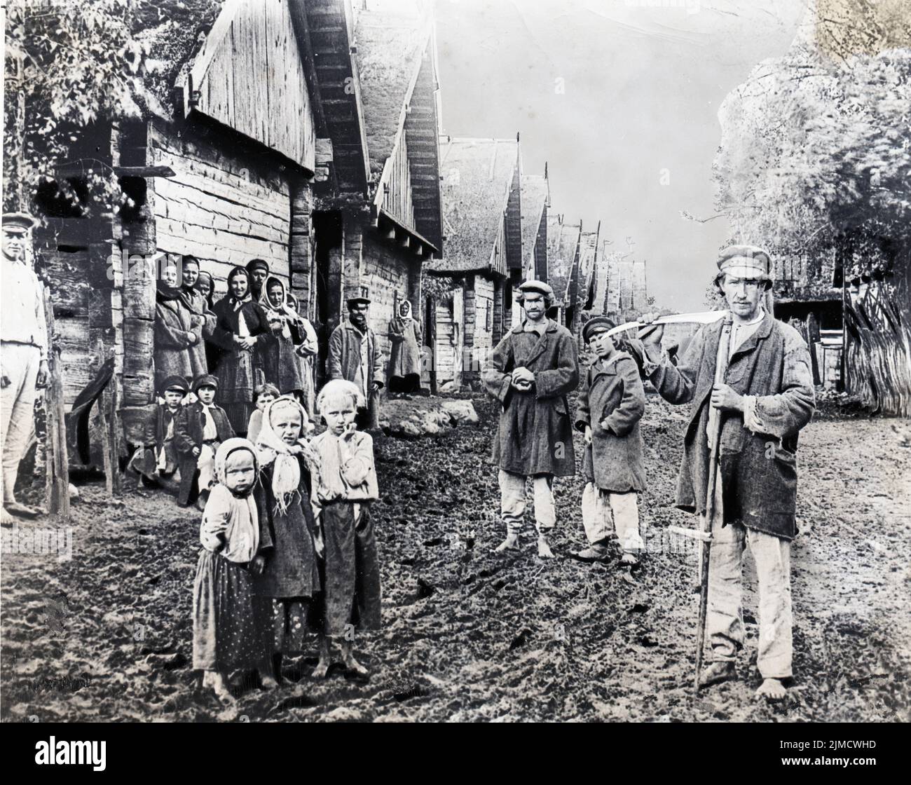 Circa 1950, Russia: Villagers stand in a muddy street lined with wood ...