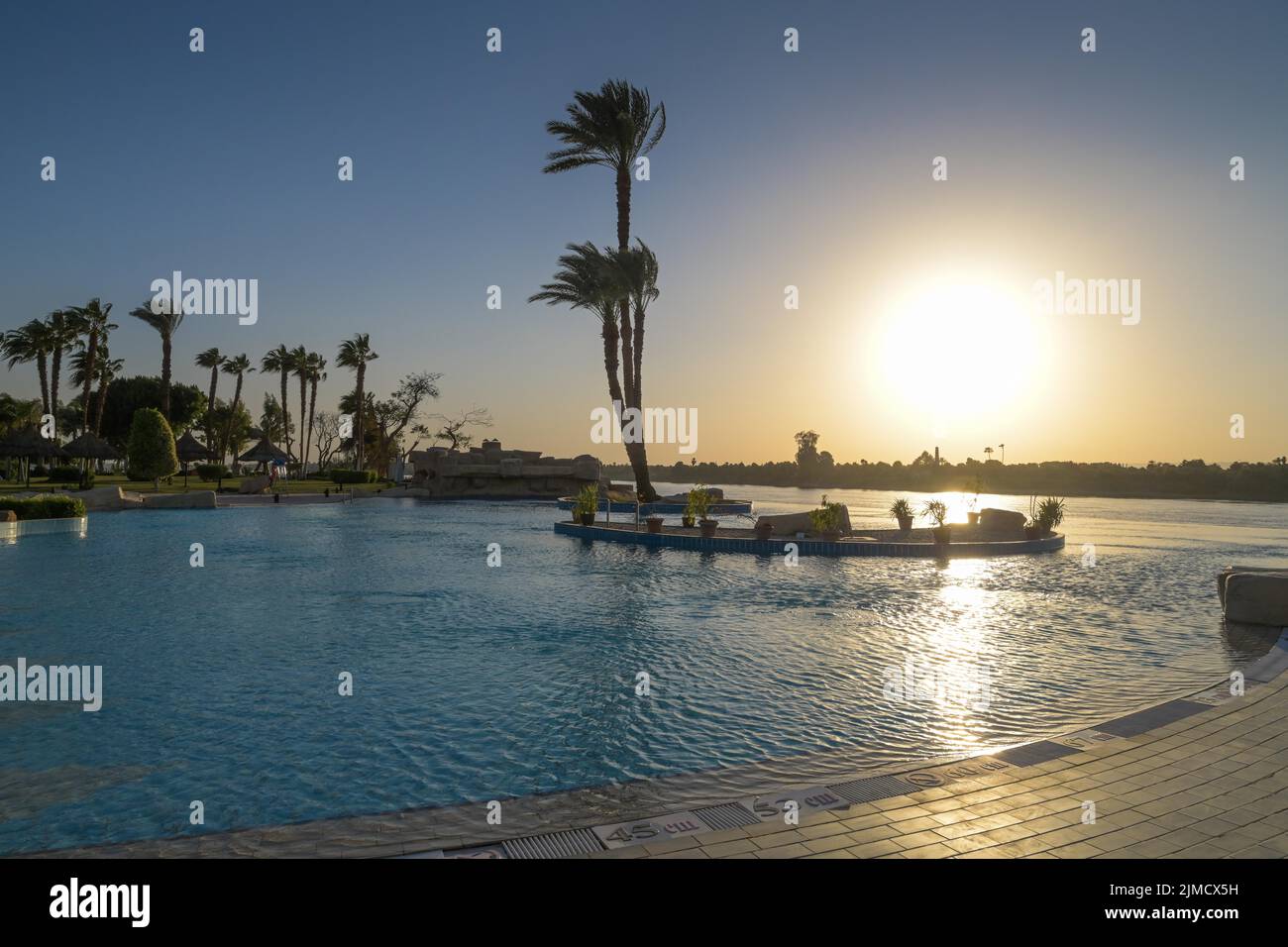 Sunset, infinity pool, Nile, palm trees, Jolie Ville hotel complex ...