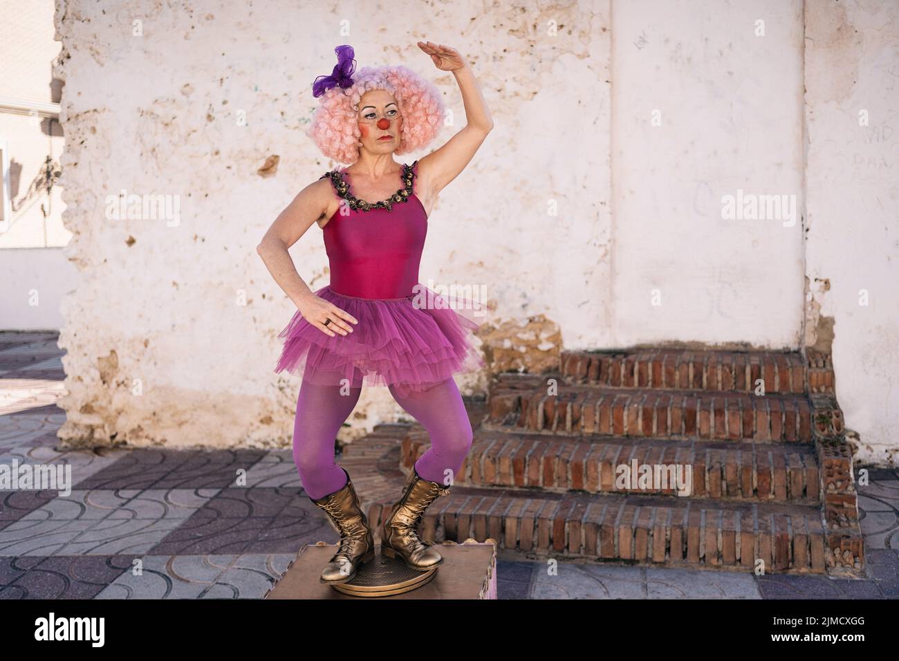Full Body Of Mature Female Mime Artist In Tutu And Pink Wig With Bright Makeup Standing On